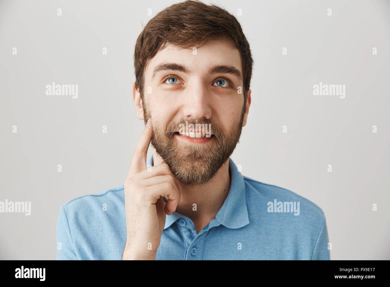 Pleased european guy dreaming or thinking about something positive ...