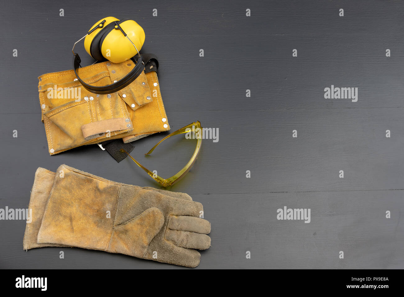 Helmet and gloves on a black workbench. Work clothing for construction ...