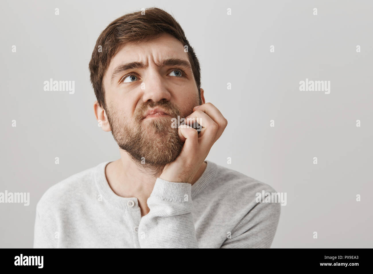 Keep growing beard or shave it. Close-up shot of confused questioned ...