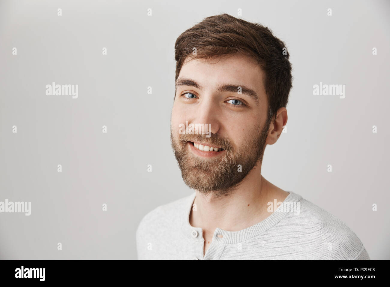 Portrait of attractive charming bearded guy with kind smile standing ...