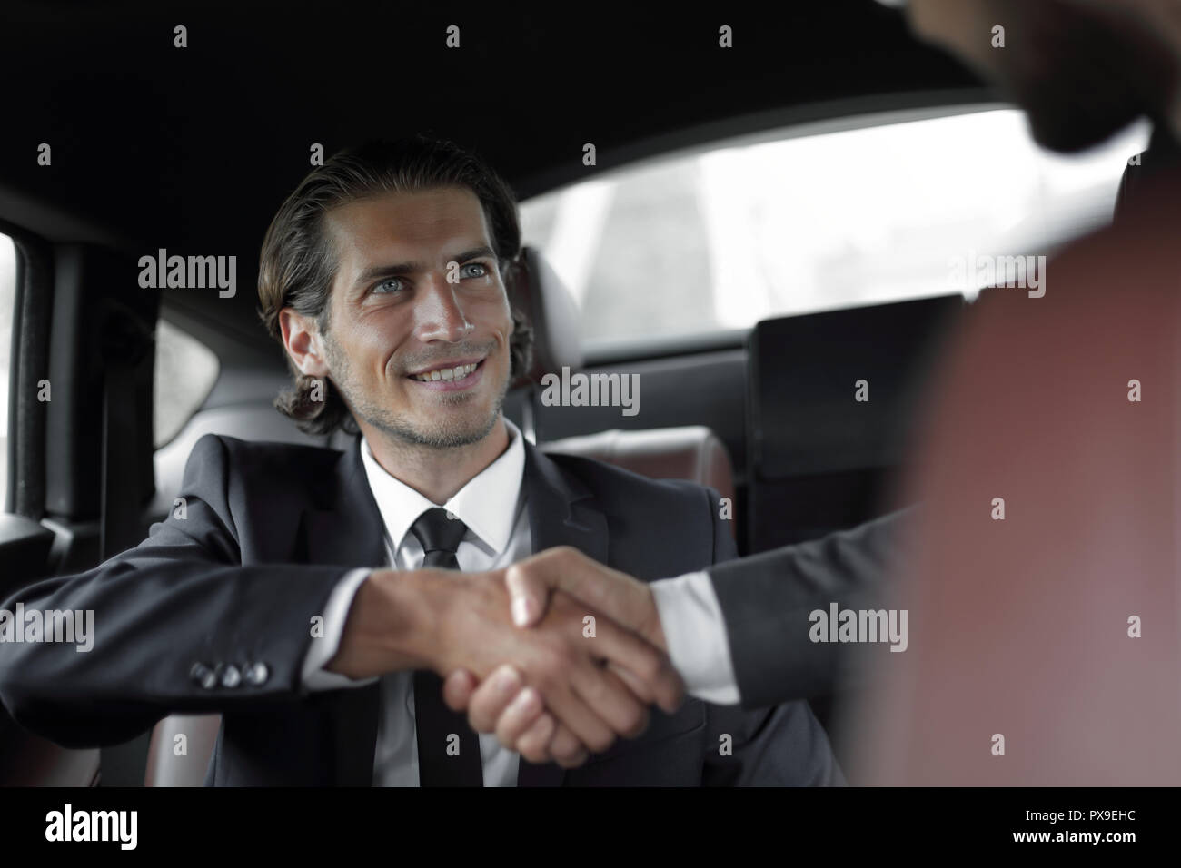 handshake of business partners sitting in the car Stock Photo - Alamy