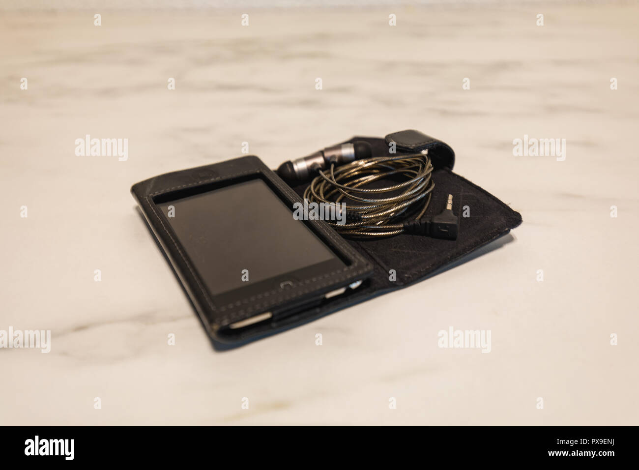 Smartphone with grey headphones on a marble plate closeup Stock Photo ...