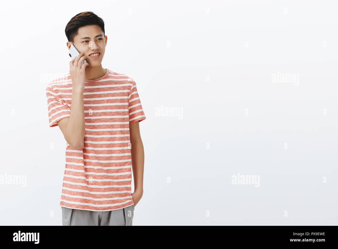 Guy calling friend talking casually via smartphone standing to left ...