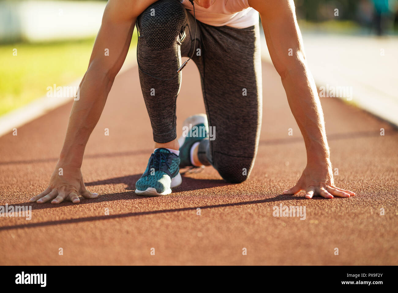 Man at start position for running at the track Stock Photo - Alamy