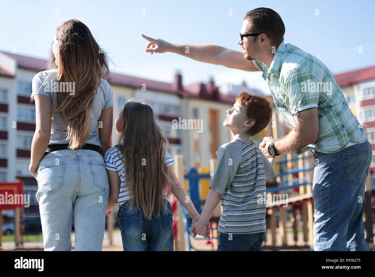 rear view.father shows his children their new home Stock Photo - Alamy