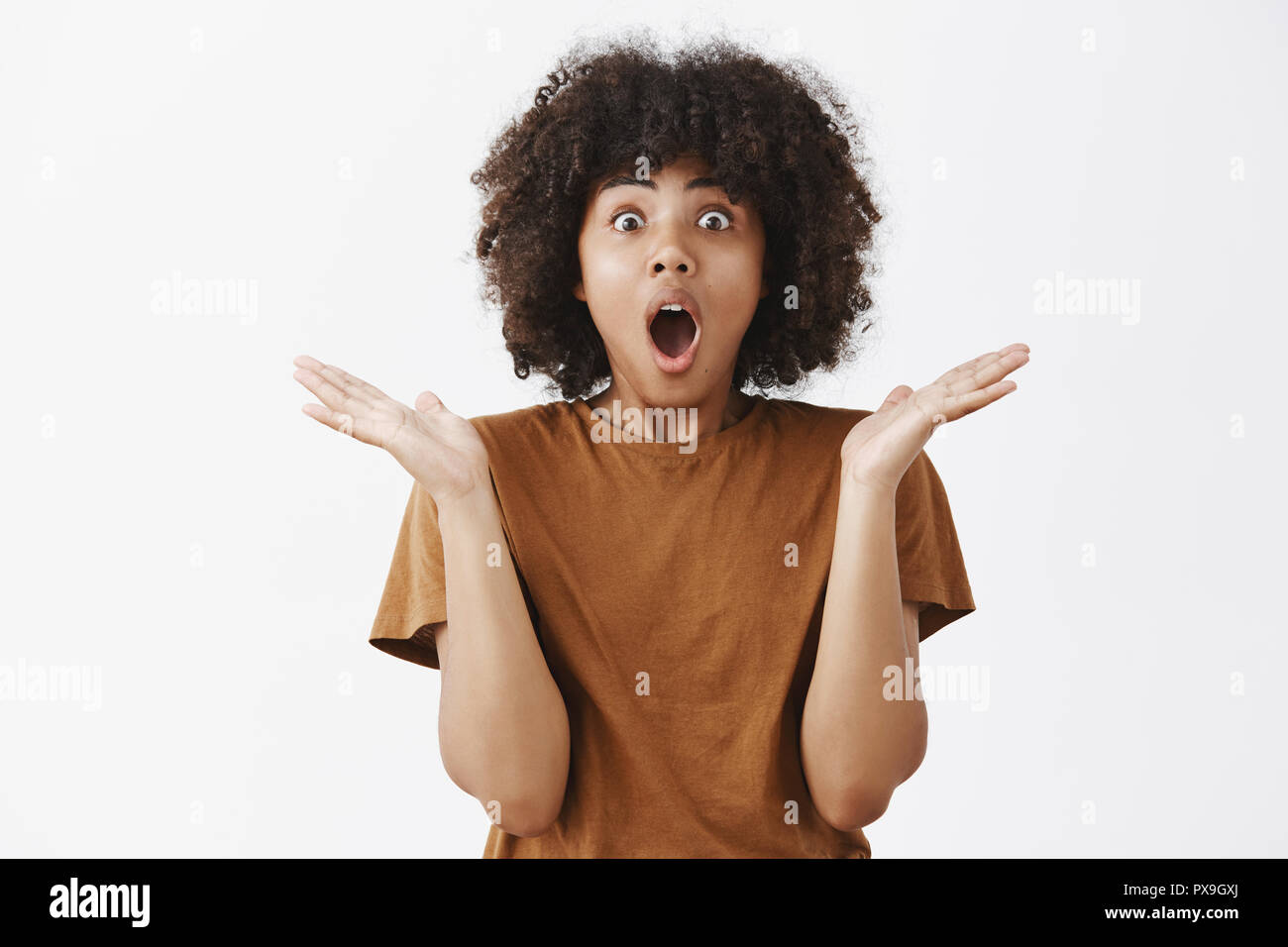 Indoor shot of excited and impressed good-looking stylish young african ...