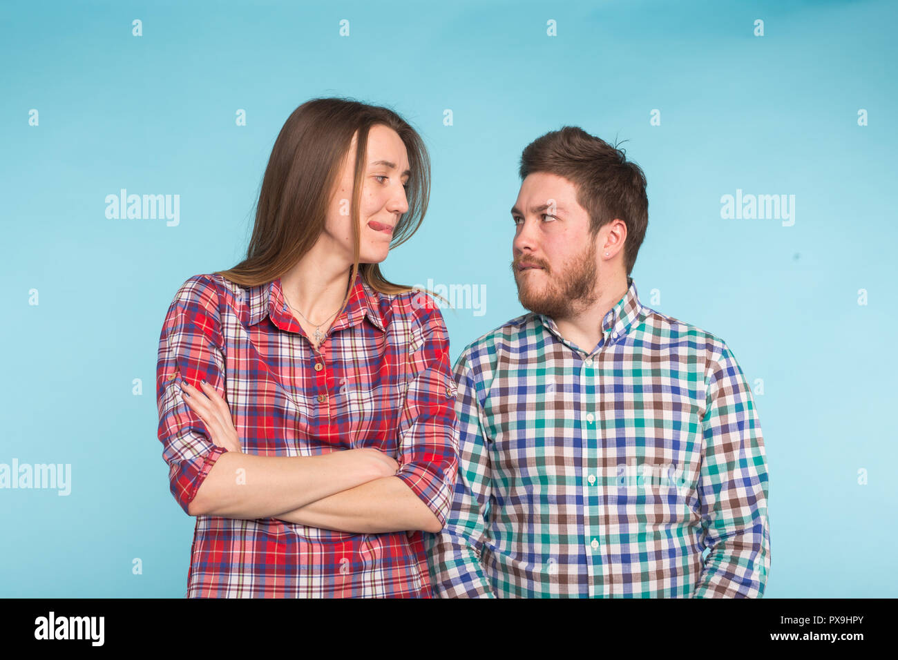 Funny young couple laughing and fooling around together on blue ...