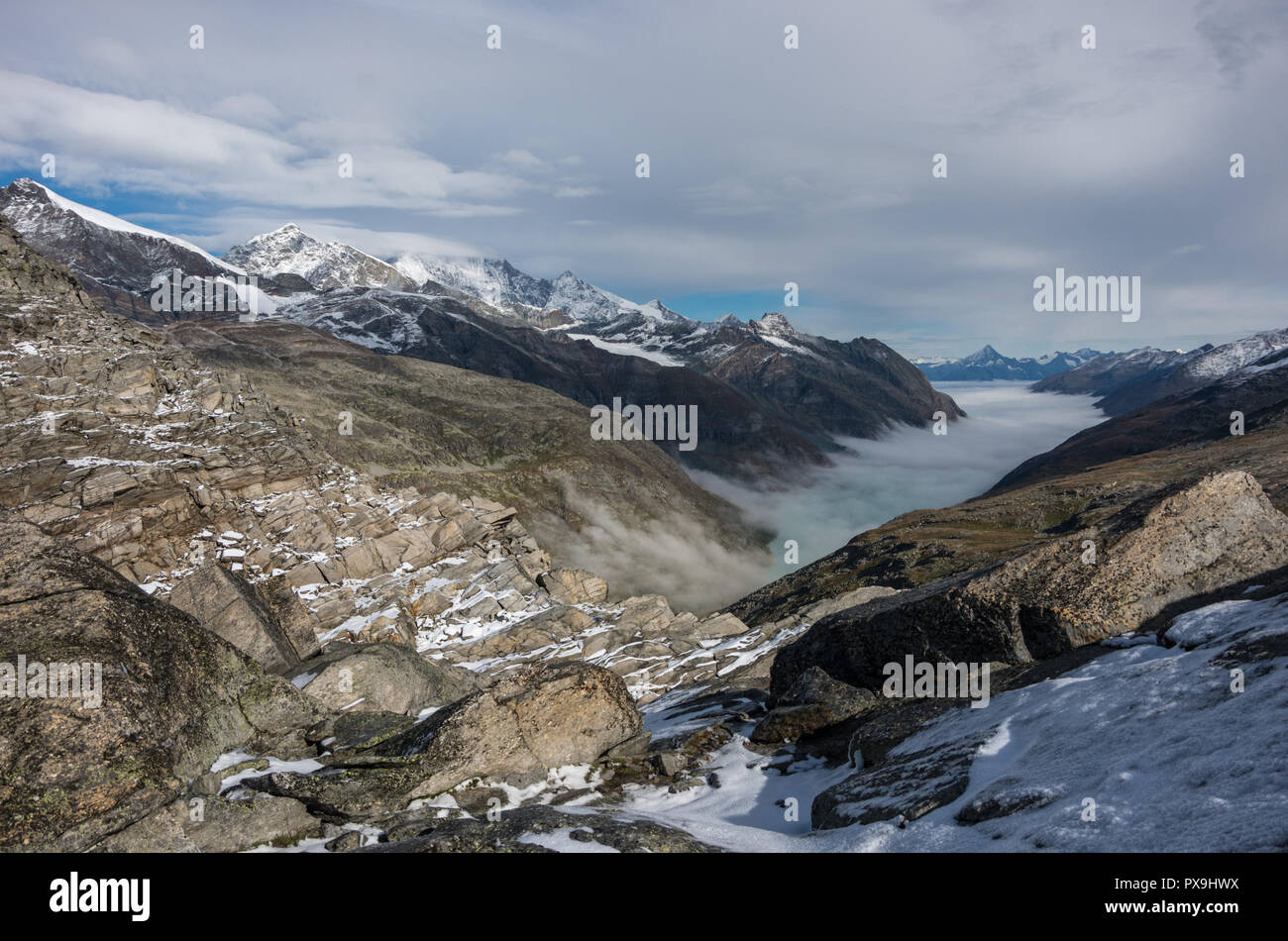 View to covered by clouds and mist Stausee lake near Saas Fee in the ...
