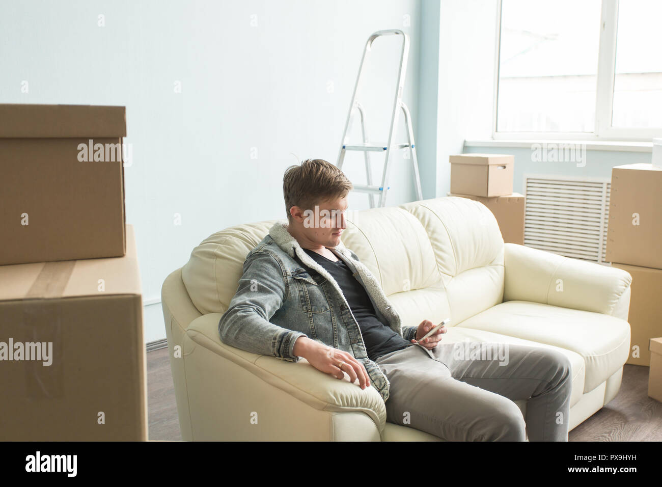 Relocation, new home and real estate concept - Cheerful young man in ...