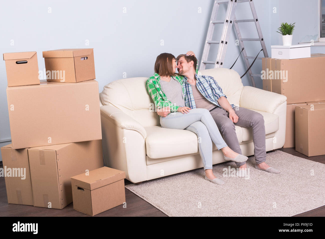New home, relocation and moving concept - young couple sitting and ...