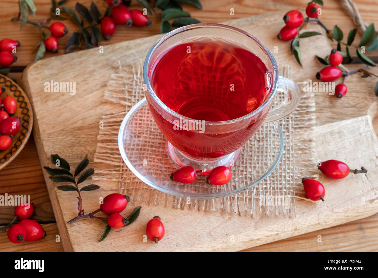 A cup of rose hip tea with fresh berries and leaves Stock Photo - Alamy