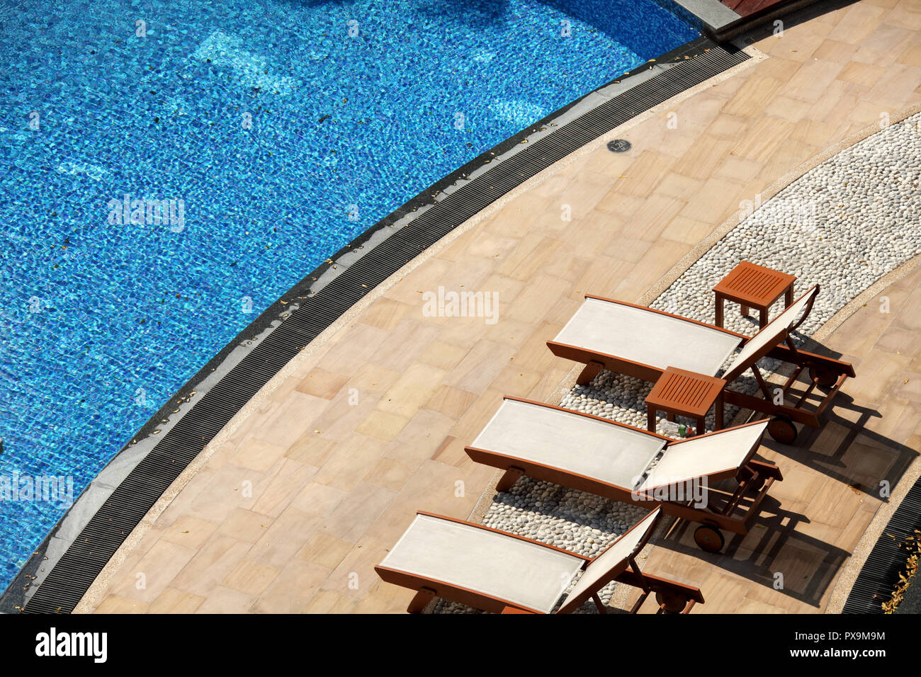 Elevated view of close up outdoor swimming pool and pool chairs with ...