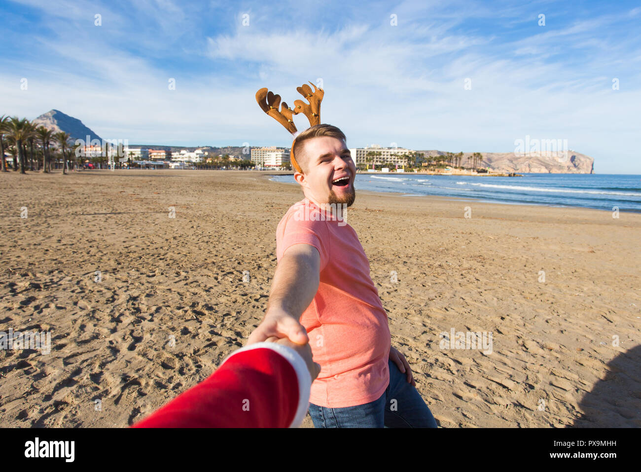 Follow me, holidays and Christmas concept - Happy young man with deer ...