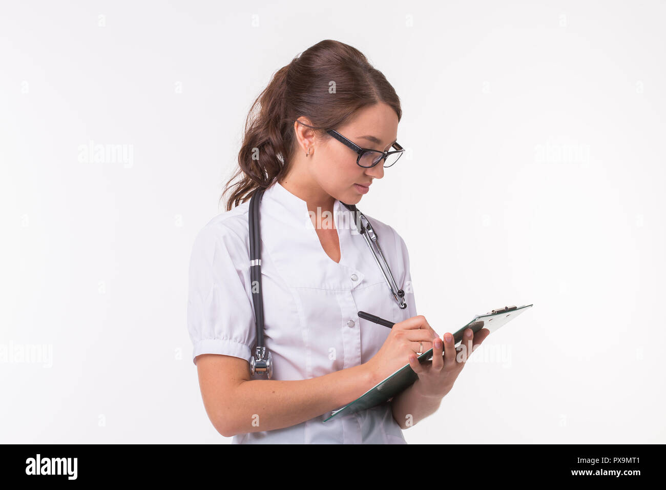 Female medicine doctor hand holding pen writing something on clipboard ...