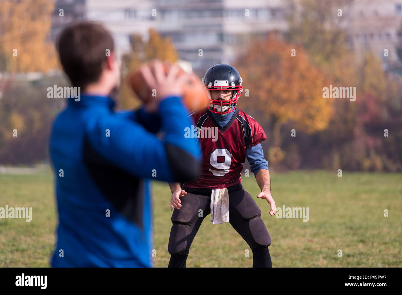 Team coach throwing the ball into the group of young american football ...