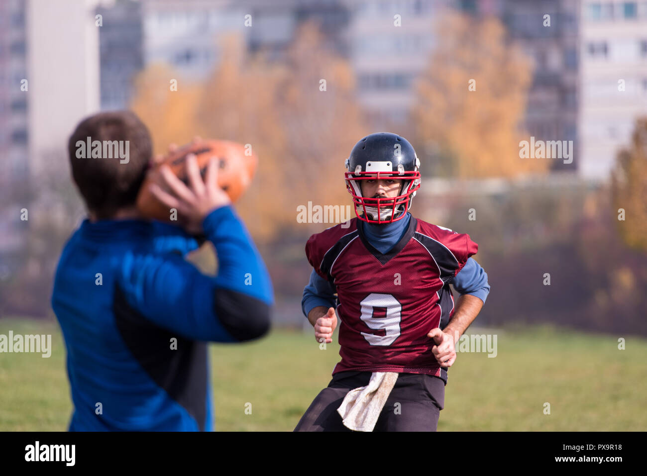 Team coach throwing the ball into the group of young american football ...