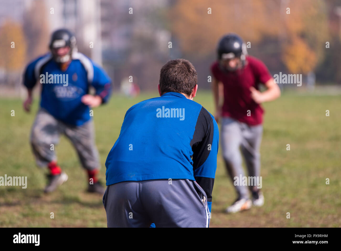 Team coach throwing the ball into the group of young american football ...