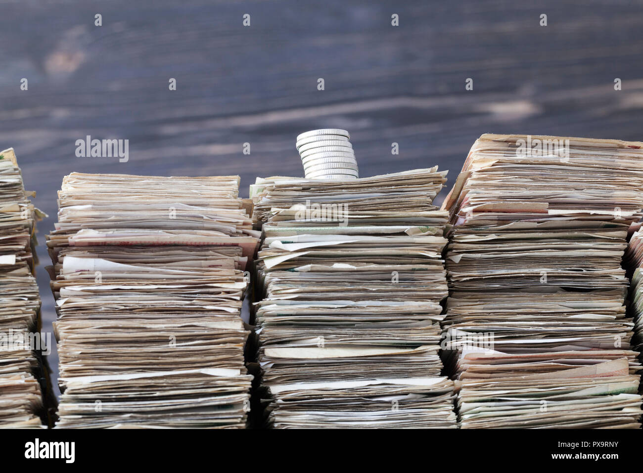 silver coins at the top of packs of old paper money, focus on coins ...