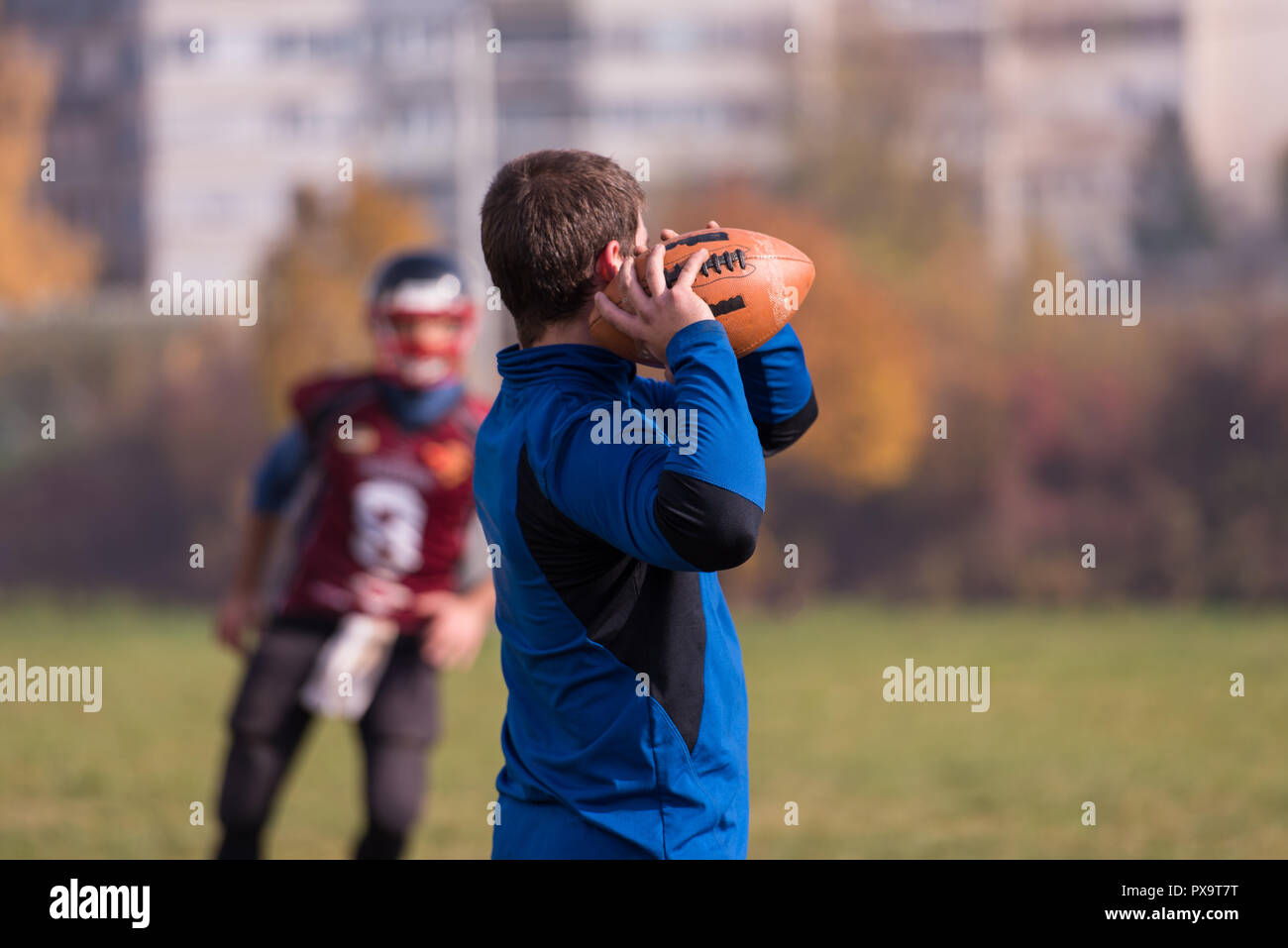 Team coach throwing the ball into the group of young american football ...