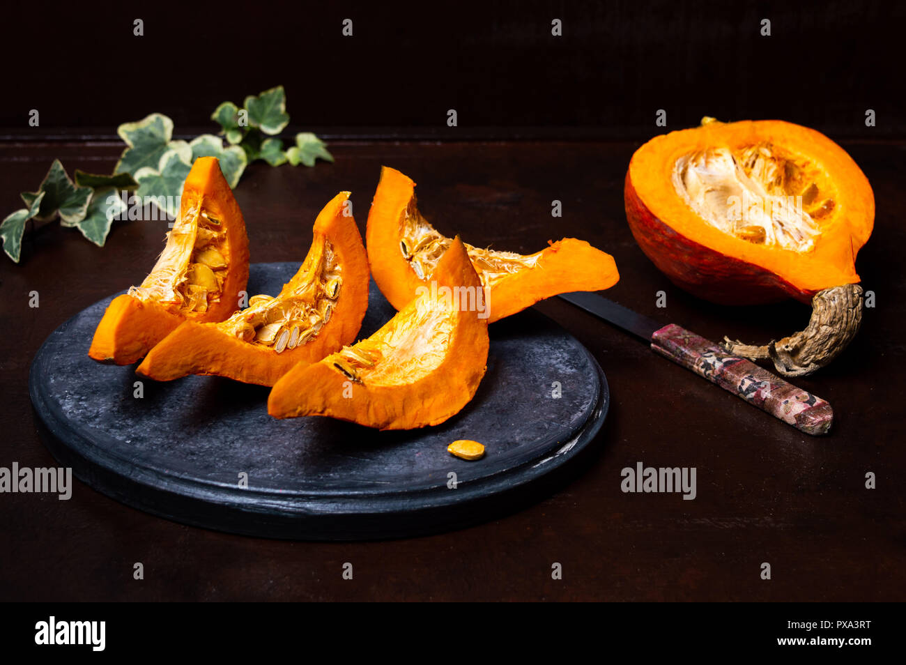Fresh opened pumpkin on a dark table top view Stock Photo - Alamy