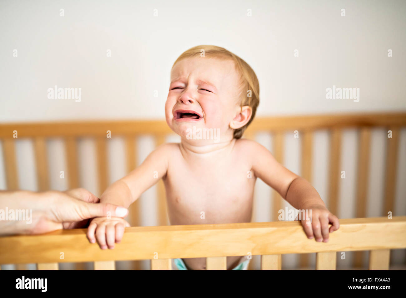 The cute baby cries and calls mum from a bed Stock Photo - Alamy
