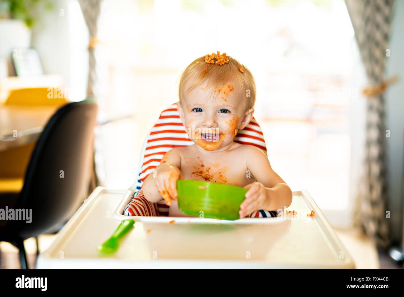 A Little baby eating her dinner and making a mess Stock Photo - Alamy