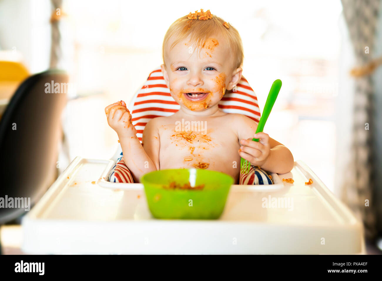 A Little baby eating her dinner and making a mess Stock Photo - Alamy