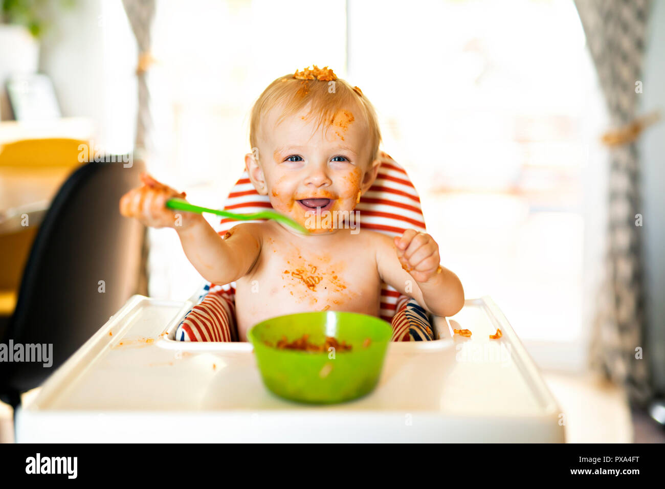 A Little baby eating her dinner and making a mess Stock Photo - Alamy