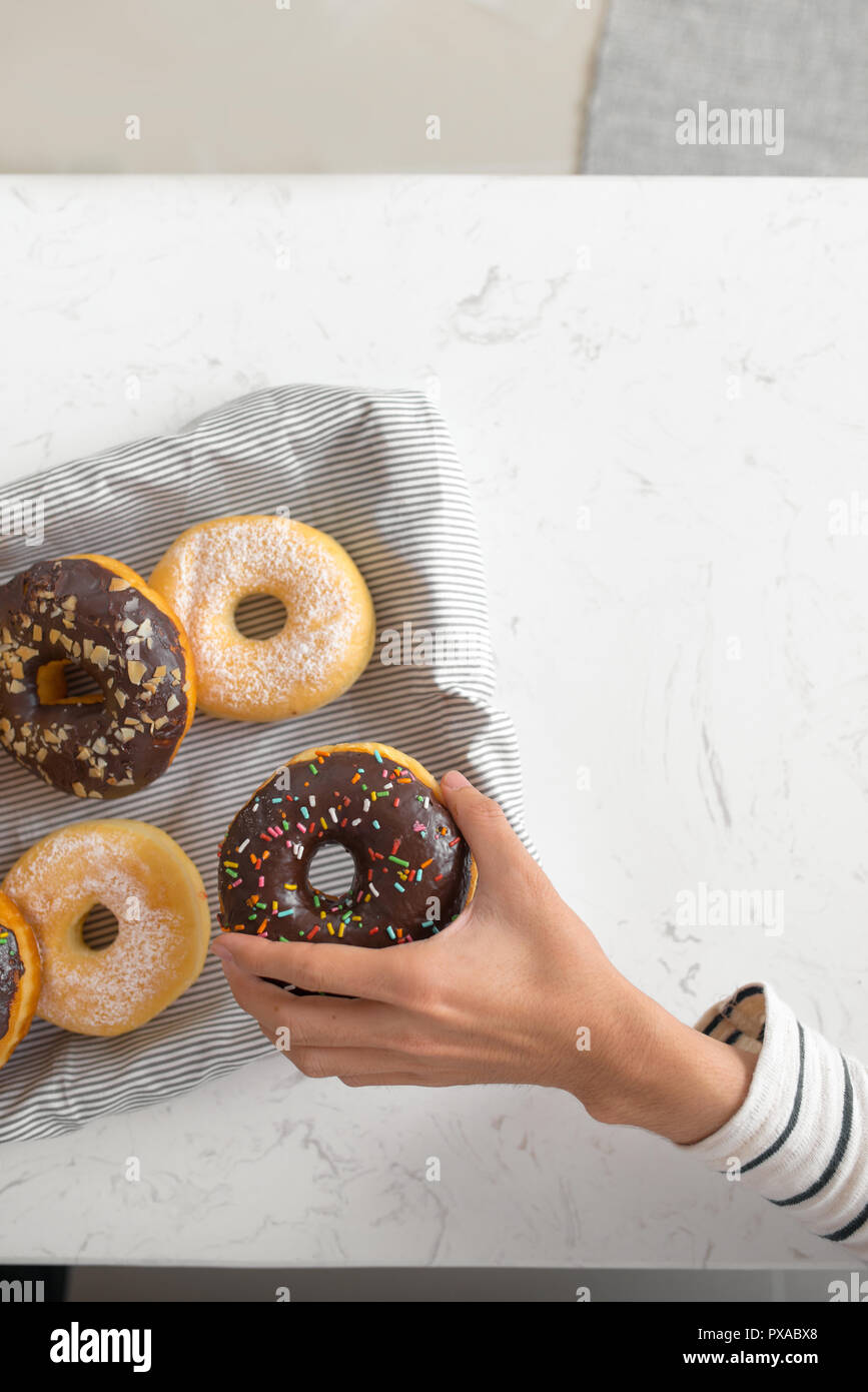Donuts in hand. Fresh homemade doughnuts with icing Stock Photo - Alamy