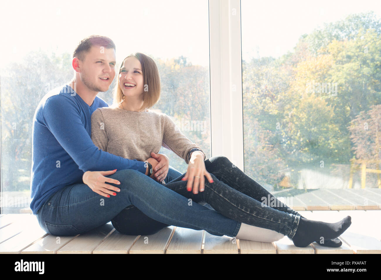 couple sitting on a window Stock Photo - Alamy