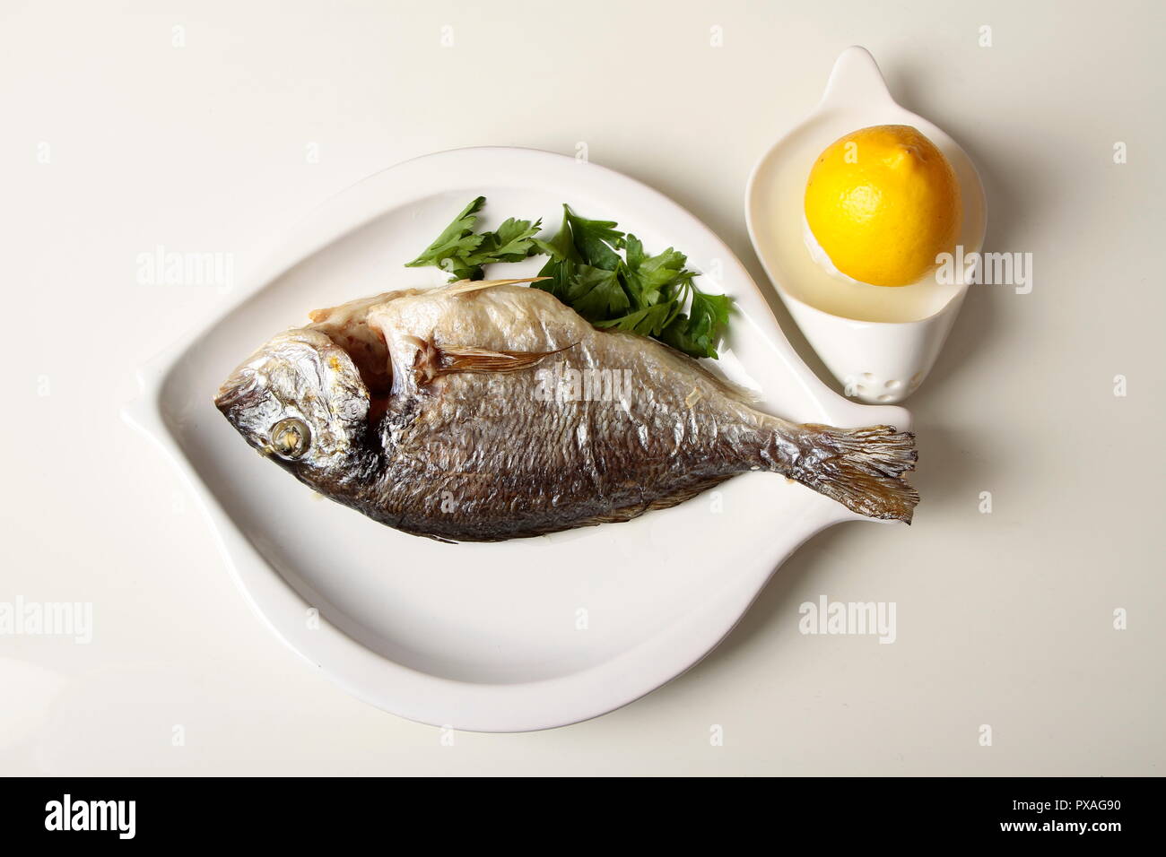 Grilled fish service Stock Photo - Alamy