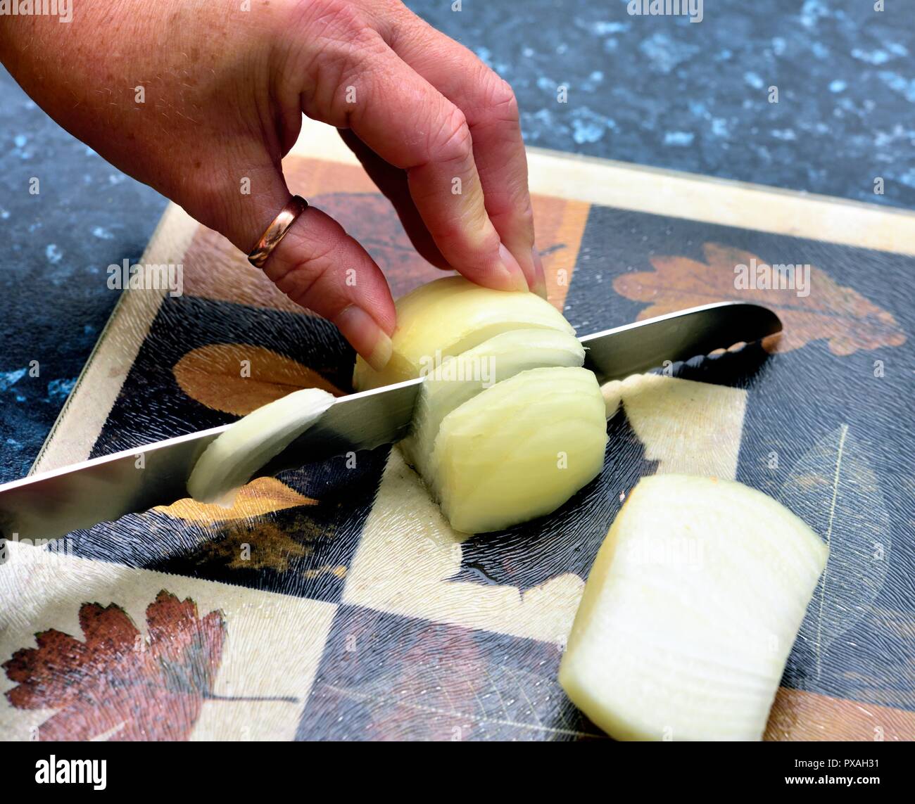 slicing a cooking onion on a chopping board Stock Photo - Alamy
