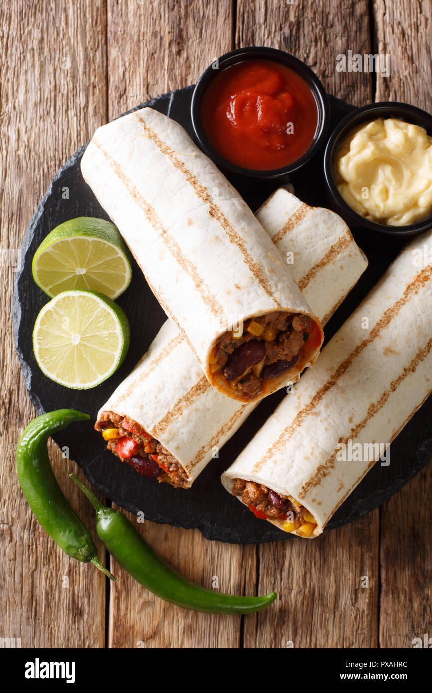 Fast food grilled burrito with beef and vegetables close-up on the ...