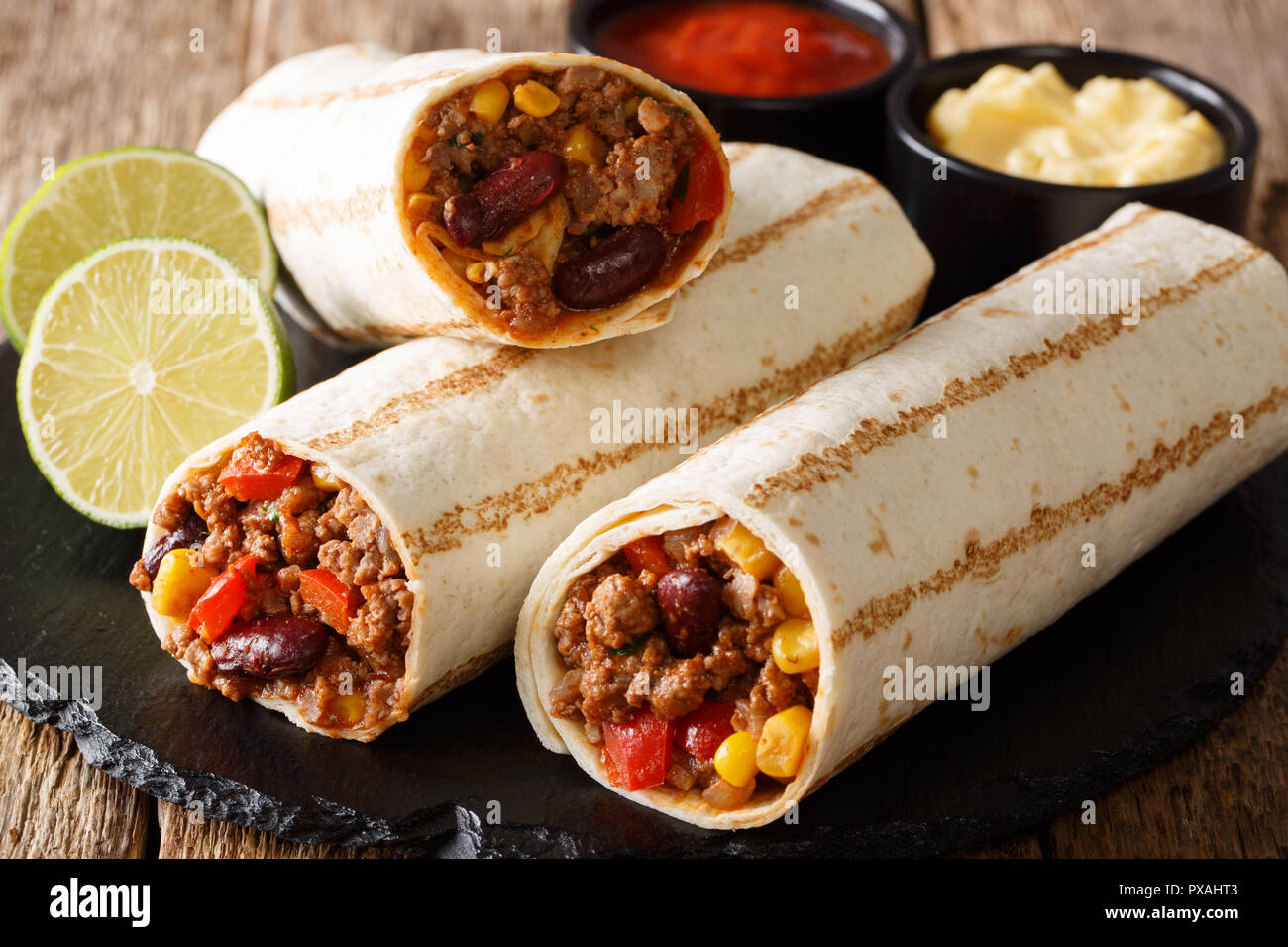 Mexican grilled burrito with beef and vegetables served with sauces ...
