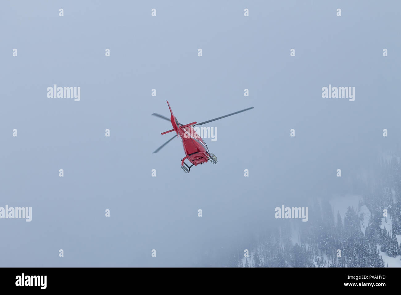 Red rescue helicopter fly in snowy mountains Stock Photo - Alamy