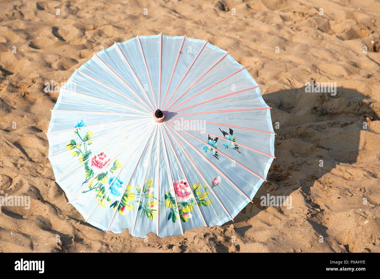 An Umbrella sits in the sand on a beach Stock Photo - Alamy