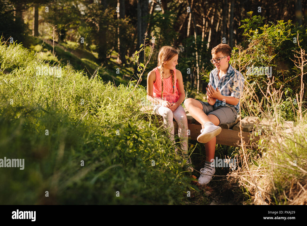 Boy girl sitting on bridge hi-res stock photography and images - Alamy