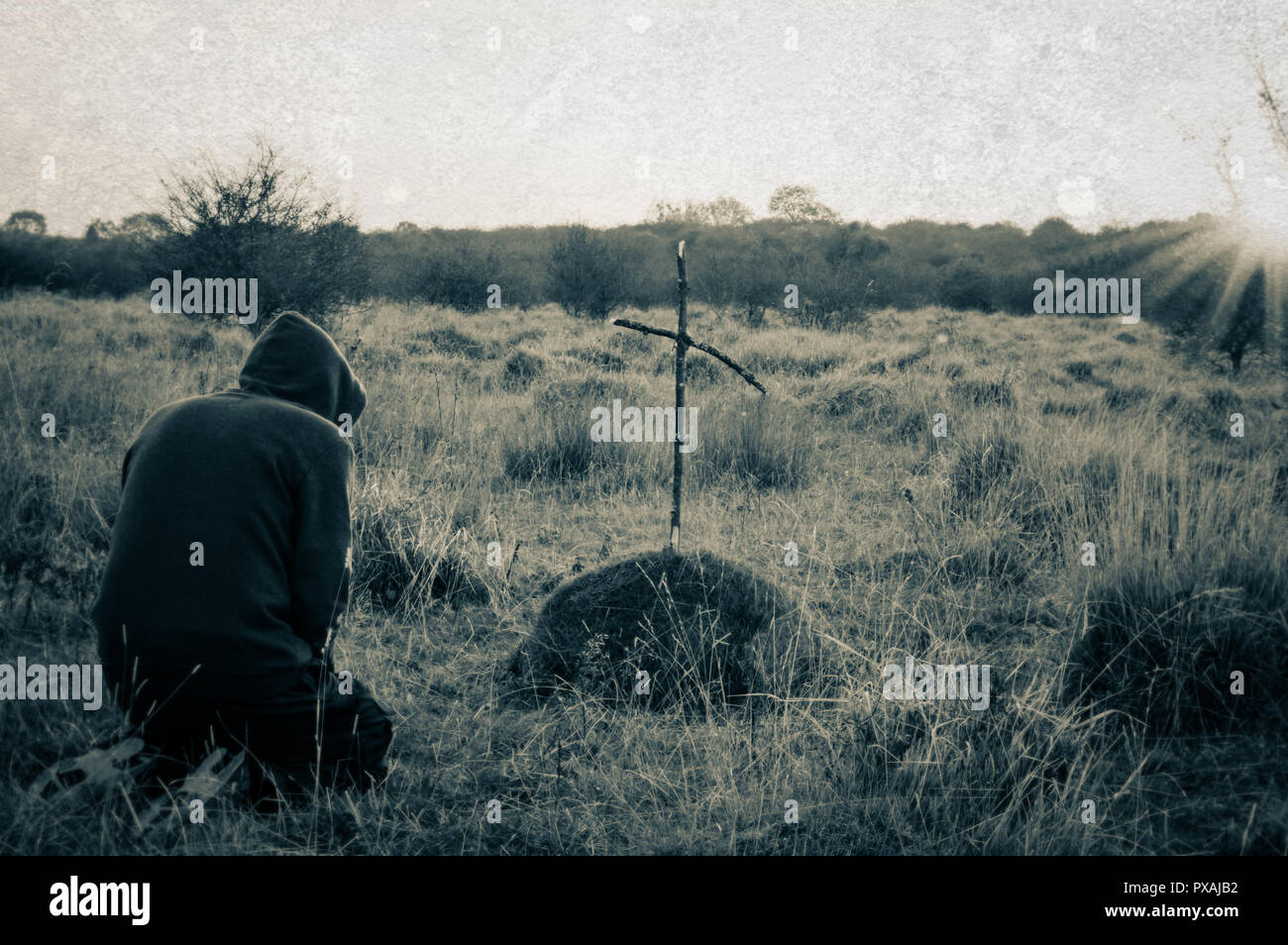 A spooky hooded figure next to a wooden cross Stock Photo - Alamy