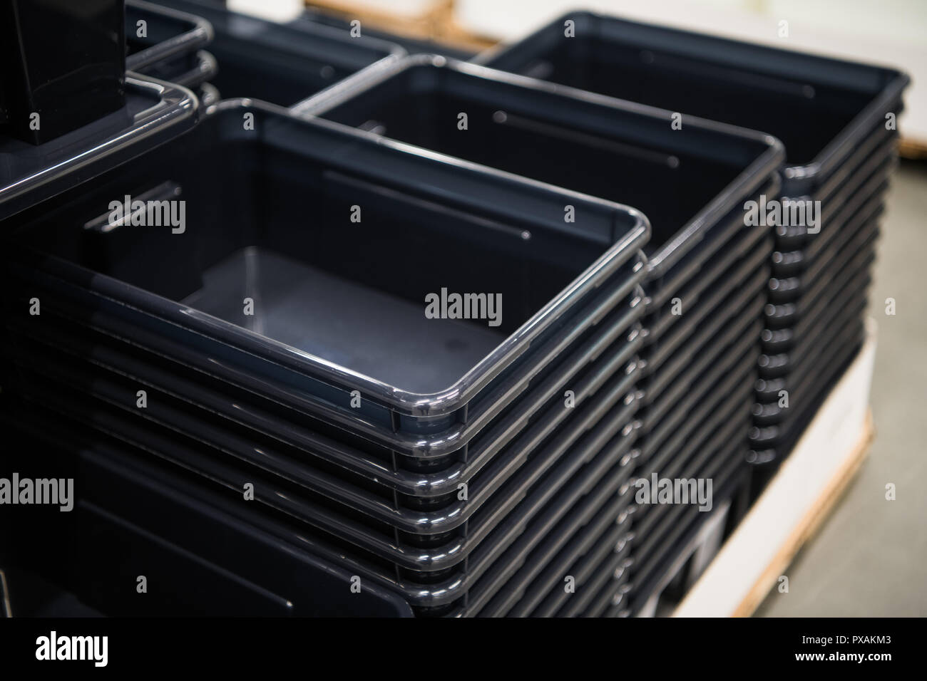 black plastic containers stack in a store Stock Photo - Alamy