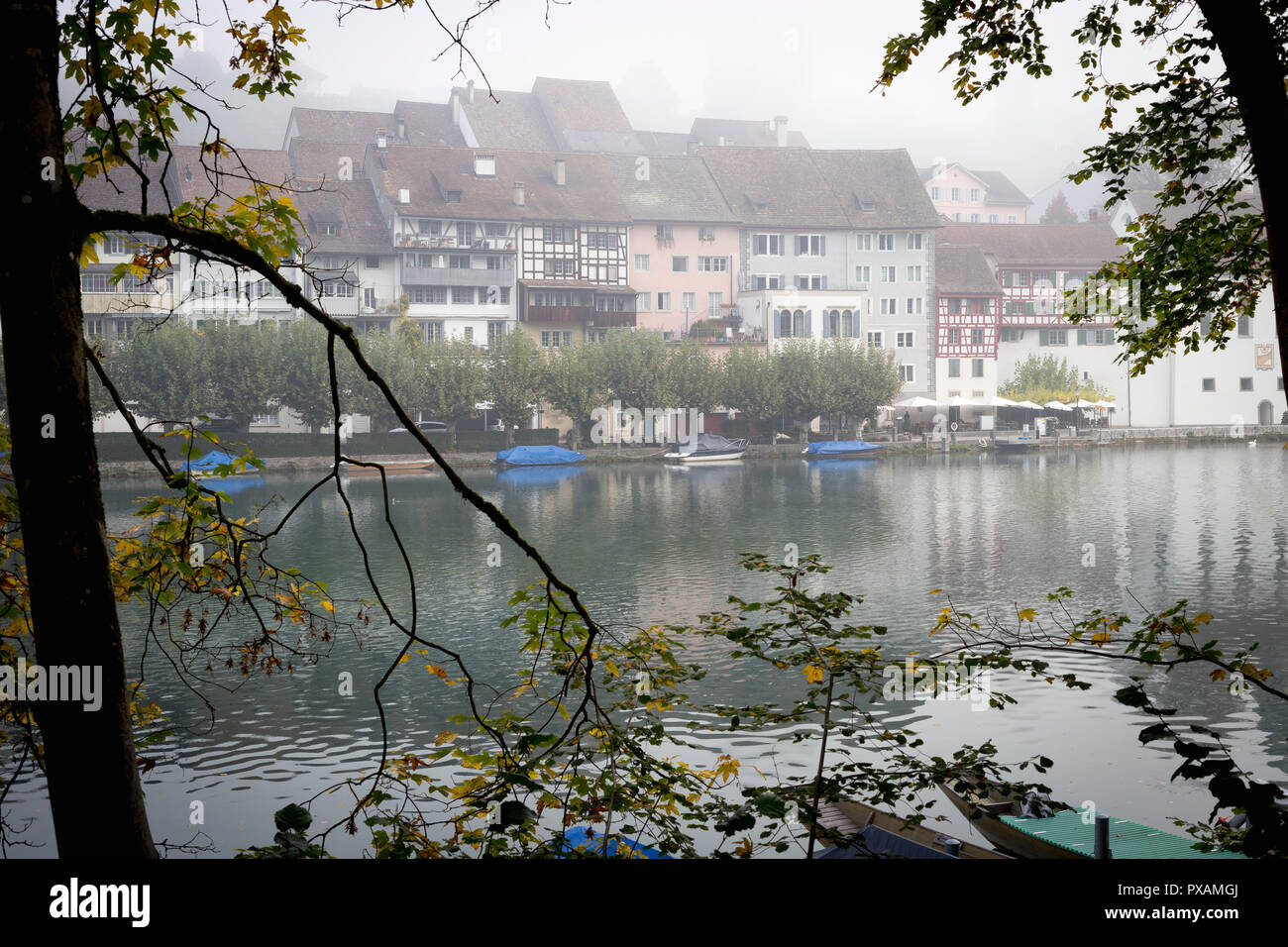 The town of Eglisau reflected on the Rhine River on a foggy morning ...