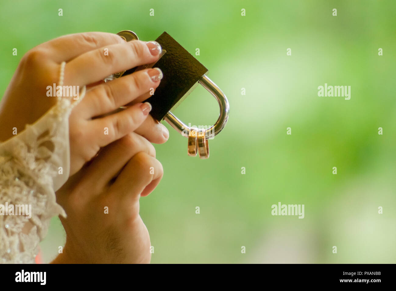 Gold wedding lock in couple's hands. Bride holding a bright wedding ...