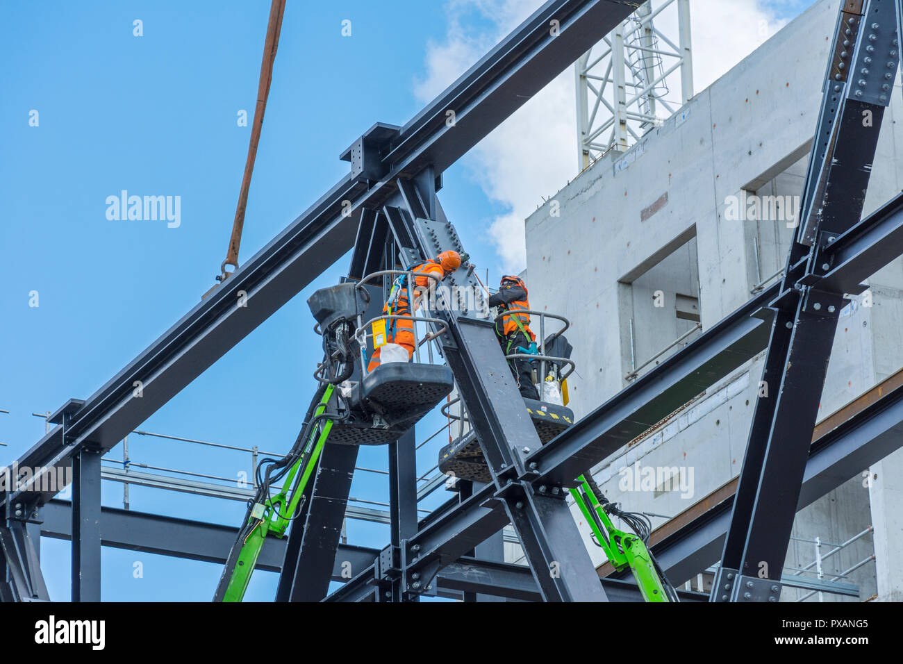 Workmen on aerial platforms erecting steelwork for the Manchester ...