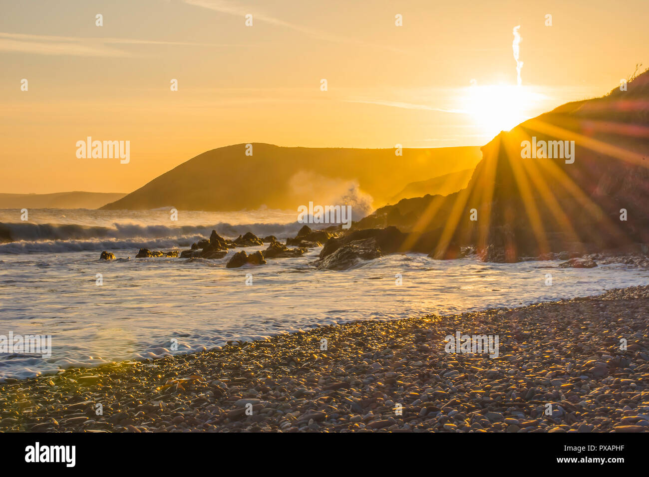 Weather uk.Vertical sun pillar visible during sunset over scenic beach ...