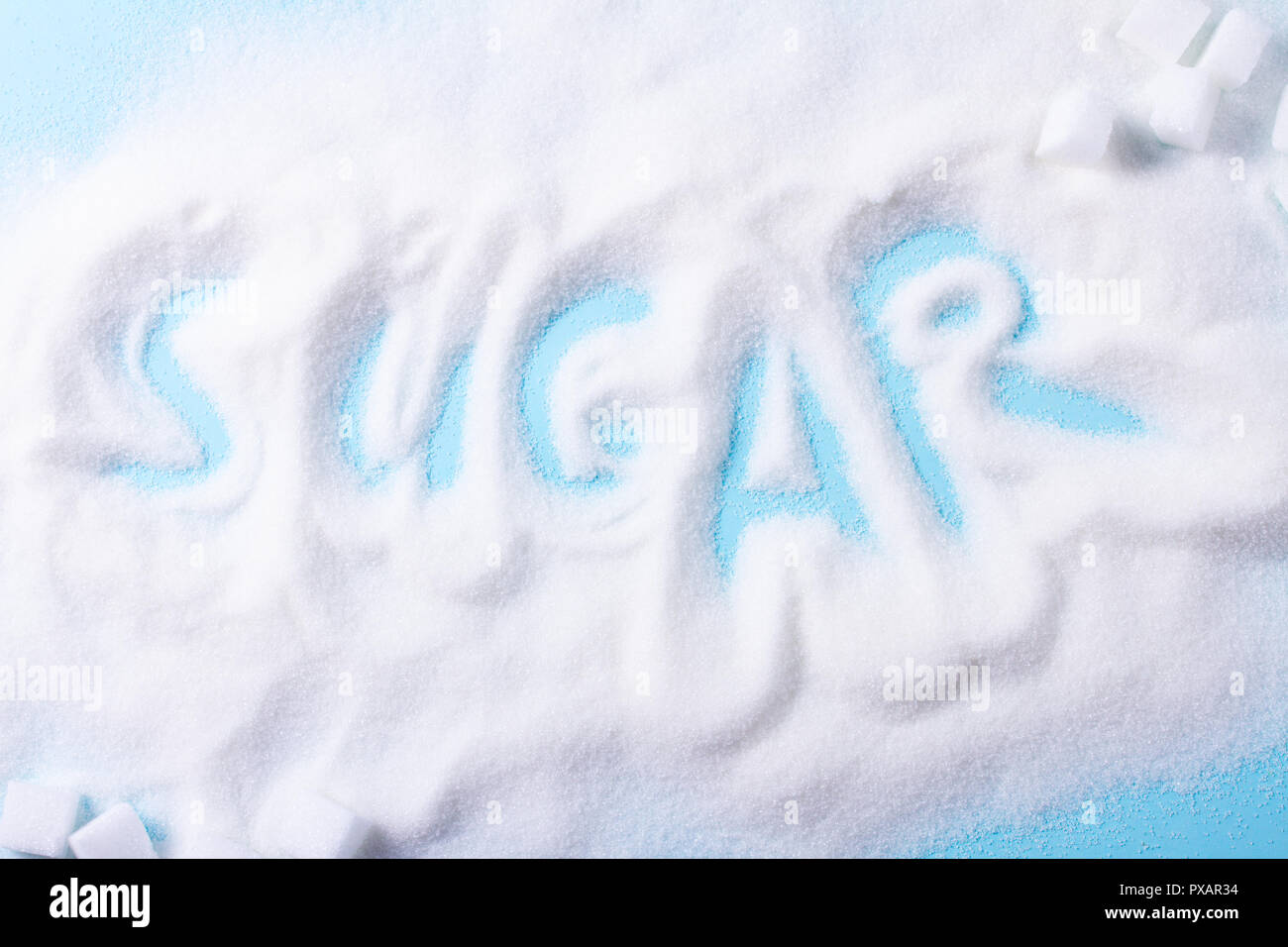 Sugar on blue background Stock Photo - Alamy