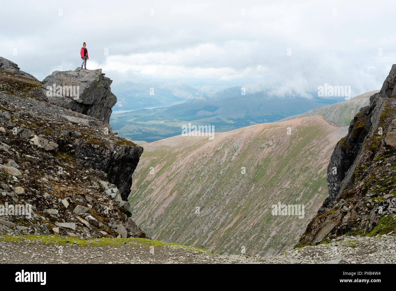 A walker in a red top gives scale to the summit of Scotland's highest ...