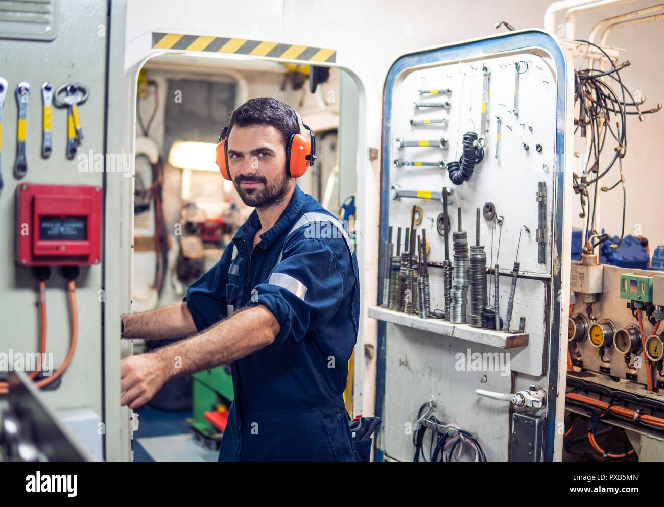 Marine engineer officer working in engine room Stock Photo - Alamy