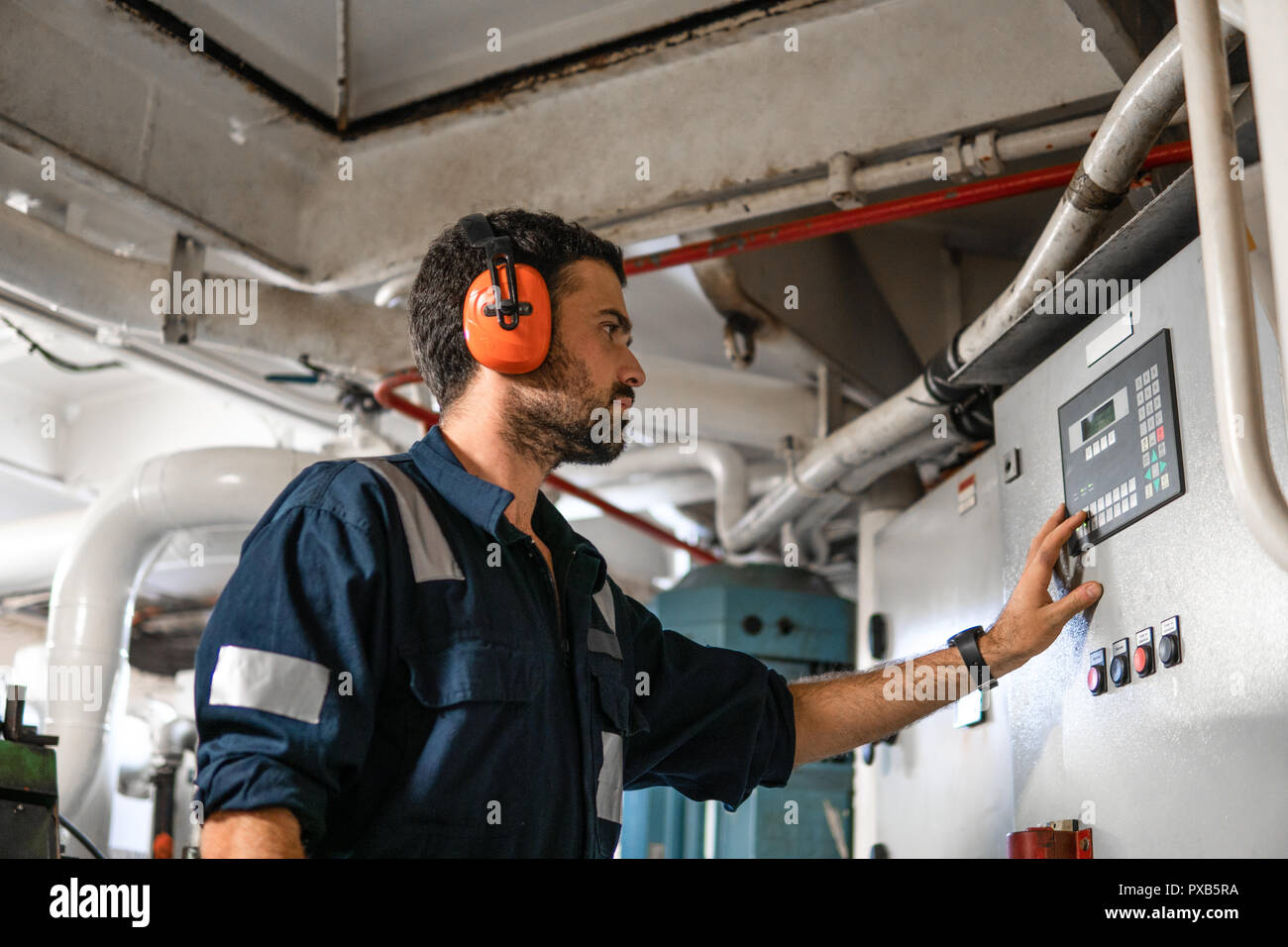Marine engineer officer working in engine room Stock Photo - Alamy