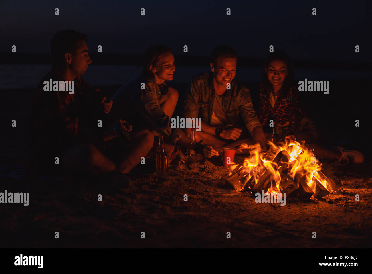 young friends have picnic with bonfire on the beach Stock Photo - Alamy