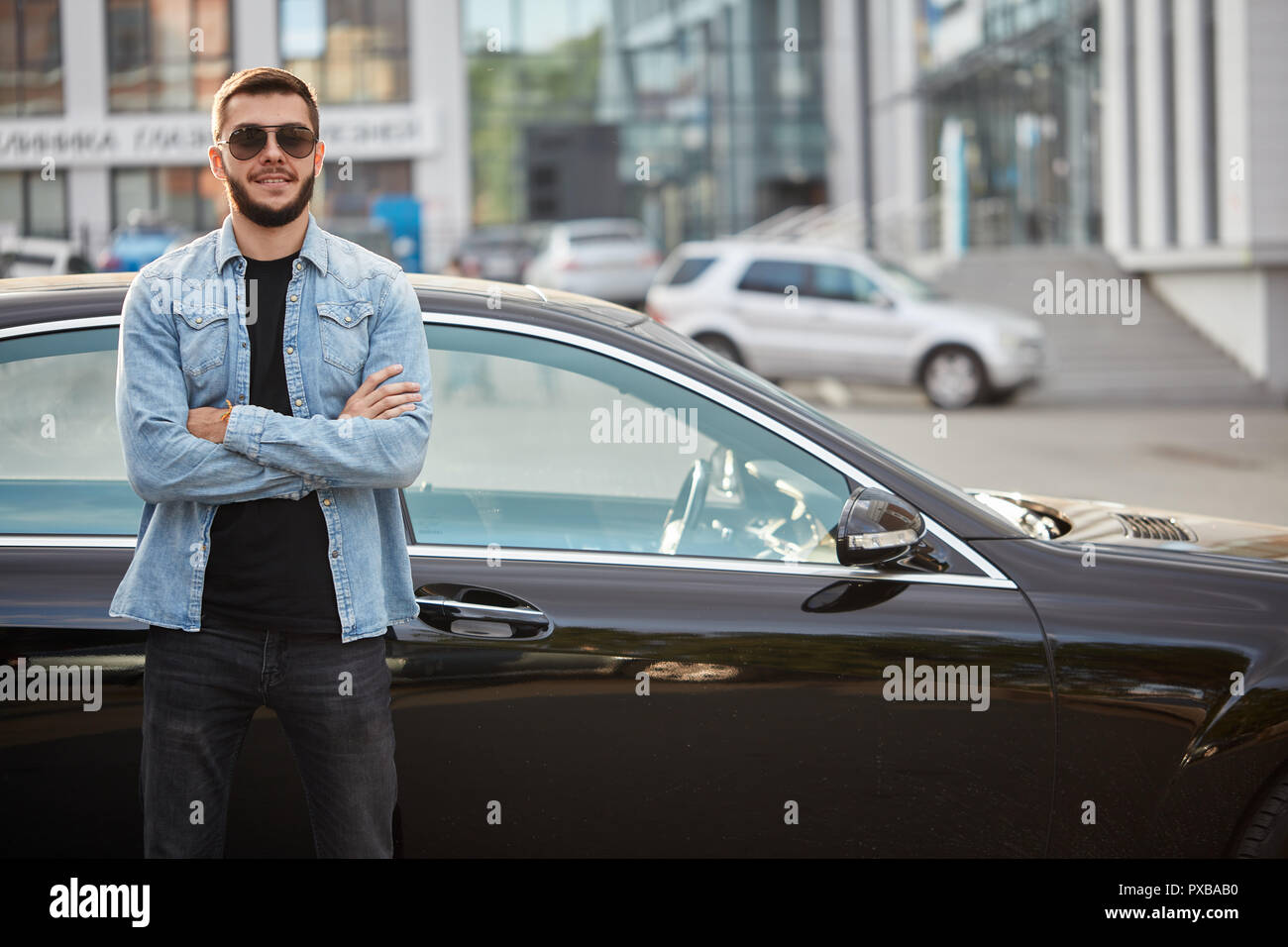Handsome smiling man standing in front of car Stock Photo - Alamy
