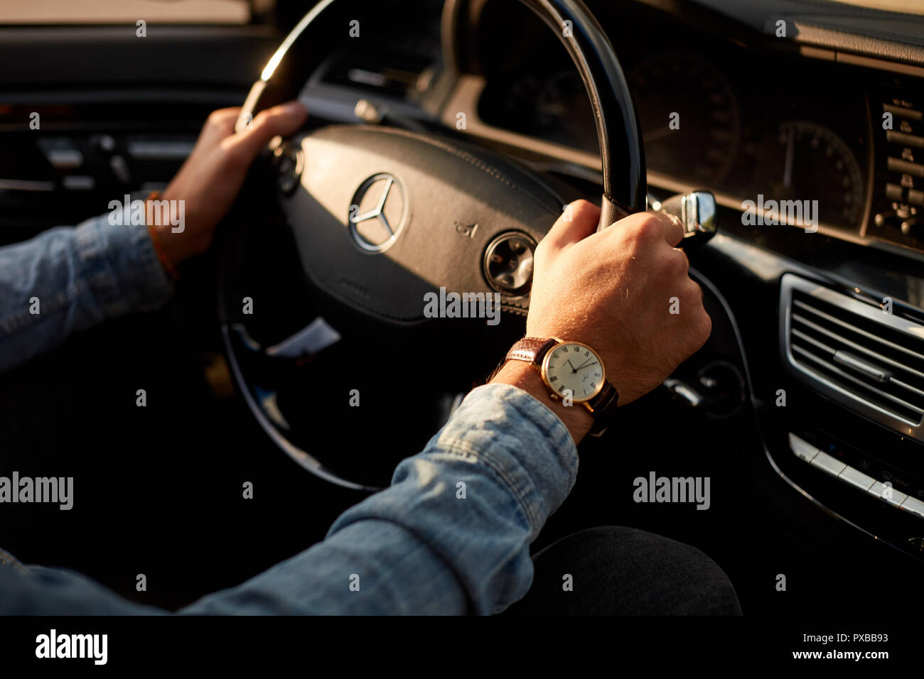 male's arms on the steering wheel Stock Photo - Alamy